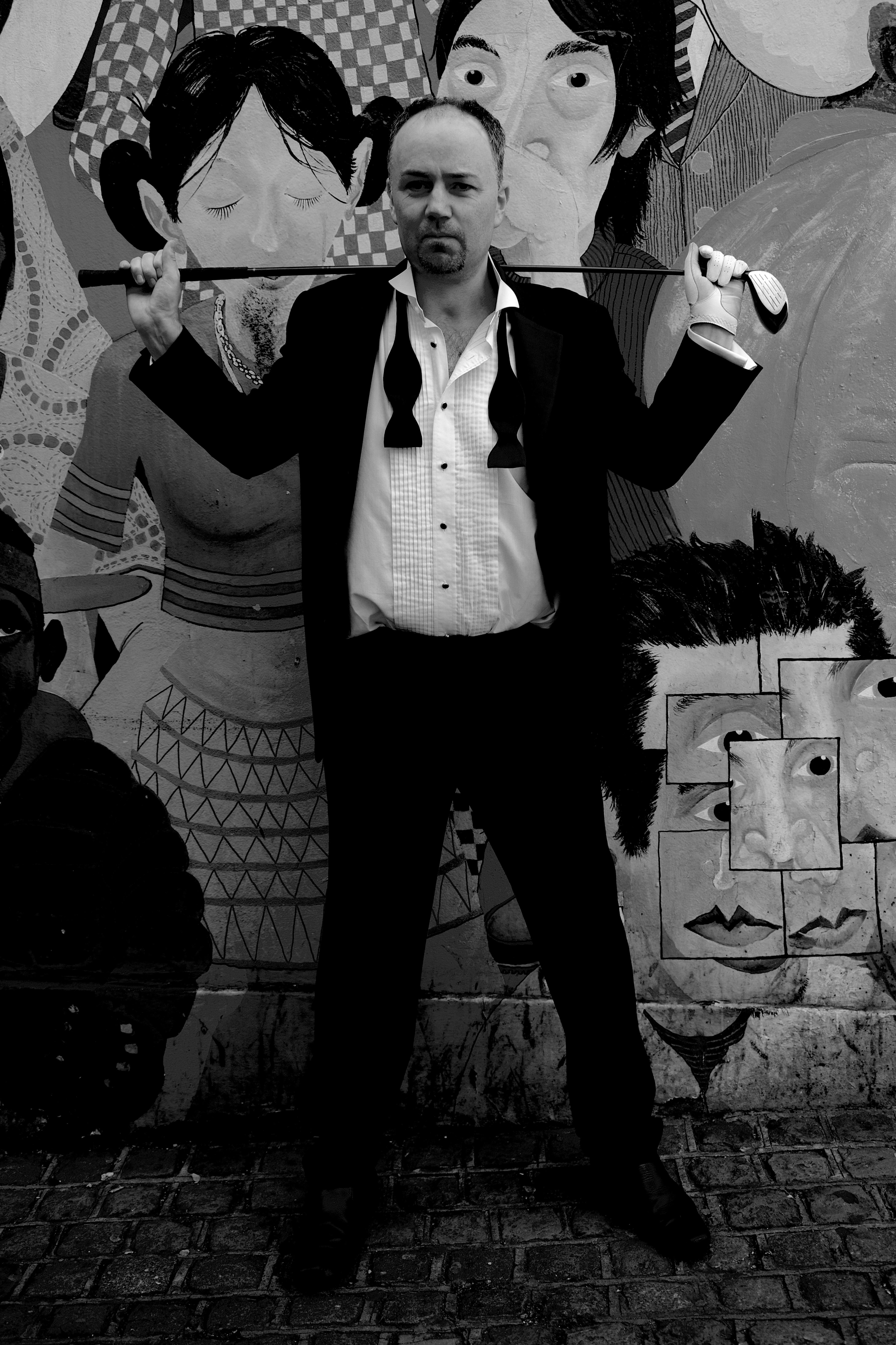 Man in DJ with golf club over shoulders (b&w) | Nick Dale – Private Tutor