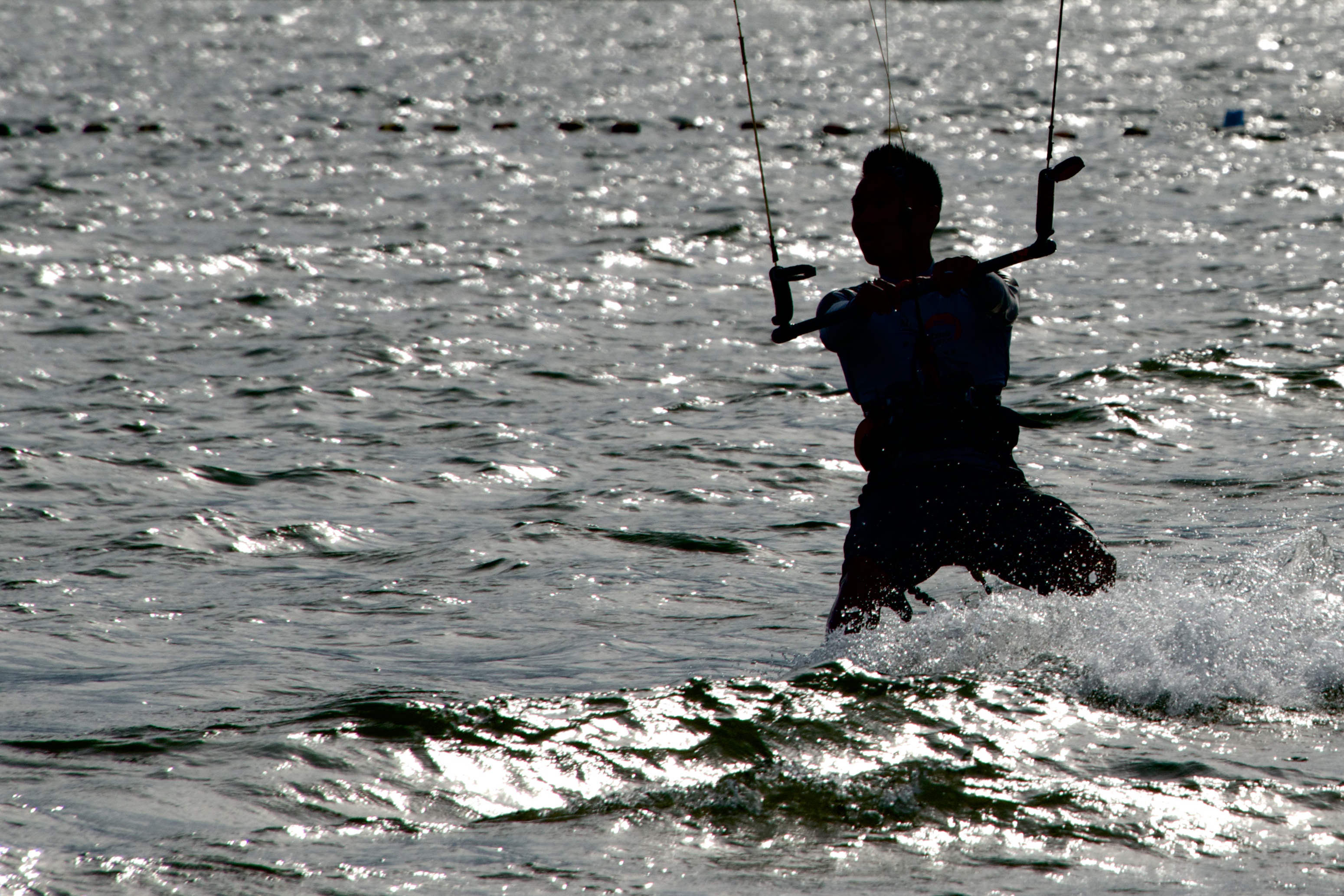 Male kite surfer backlit against bright waves - Nick Dale - Private Tutor