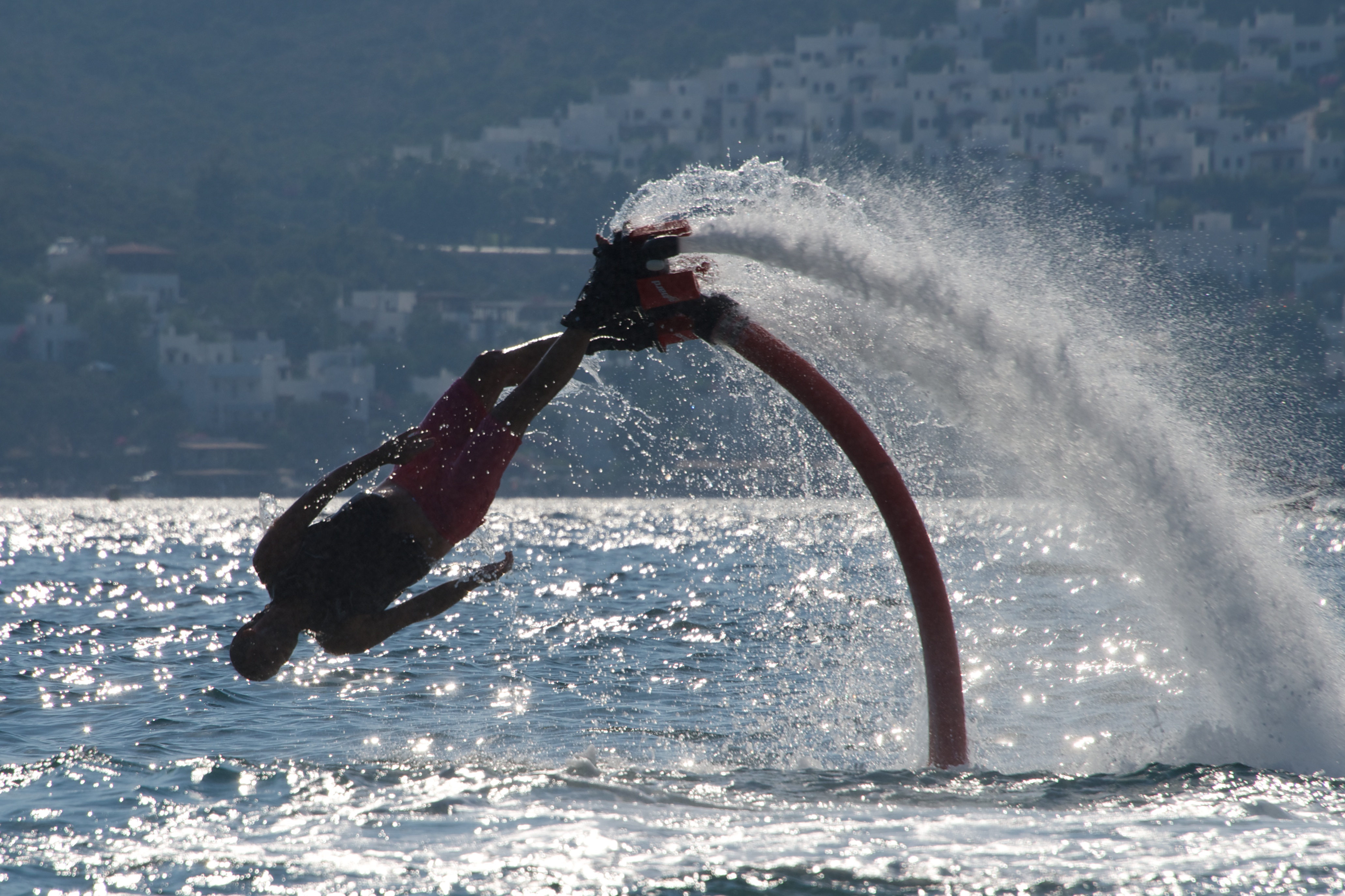 Flyboarder diving diagonally headfirst into backlit waves | Nick Dale ...