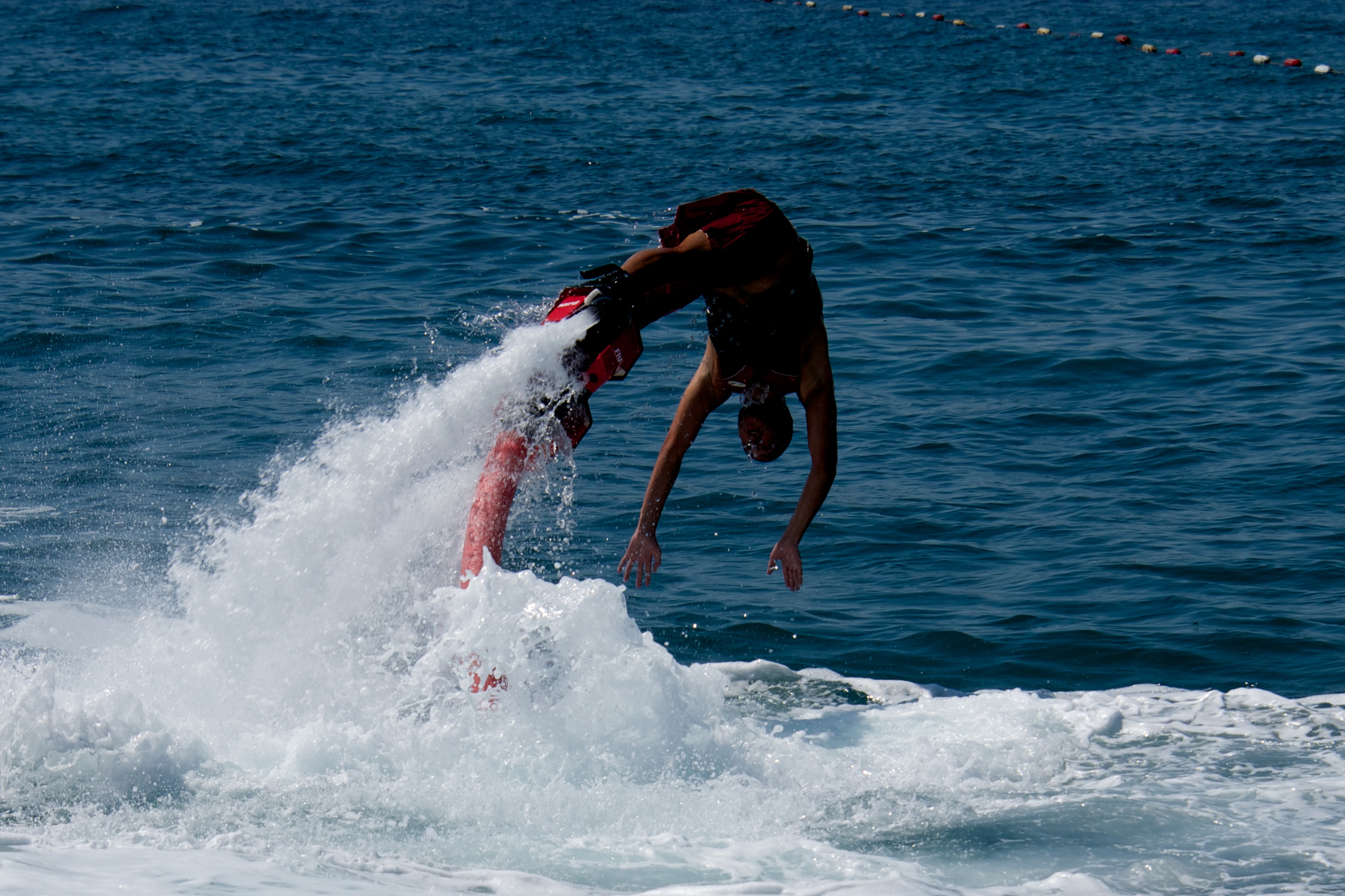 Flyboarder in red diving headfirst into whitewater - Nick Dale ...